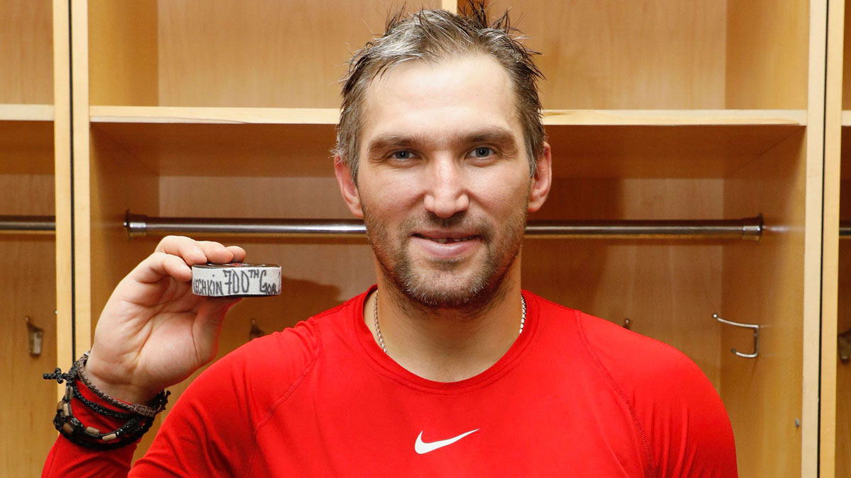 Alex Ovechkin poses with his milestone 700 goal puck